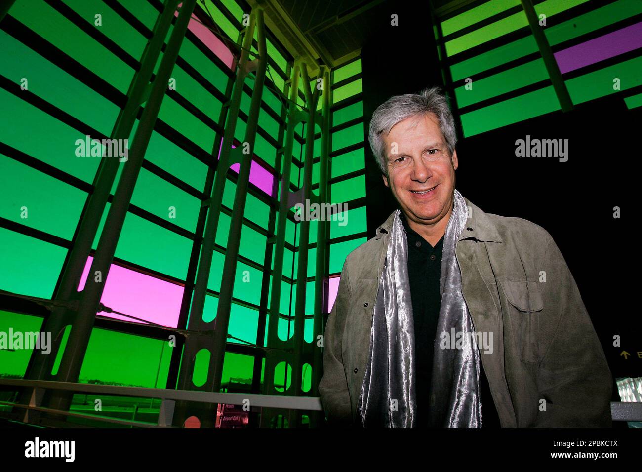 Artist Christopher Janney stands under the green and magenta tinted ...
