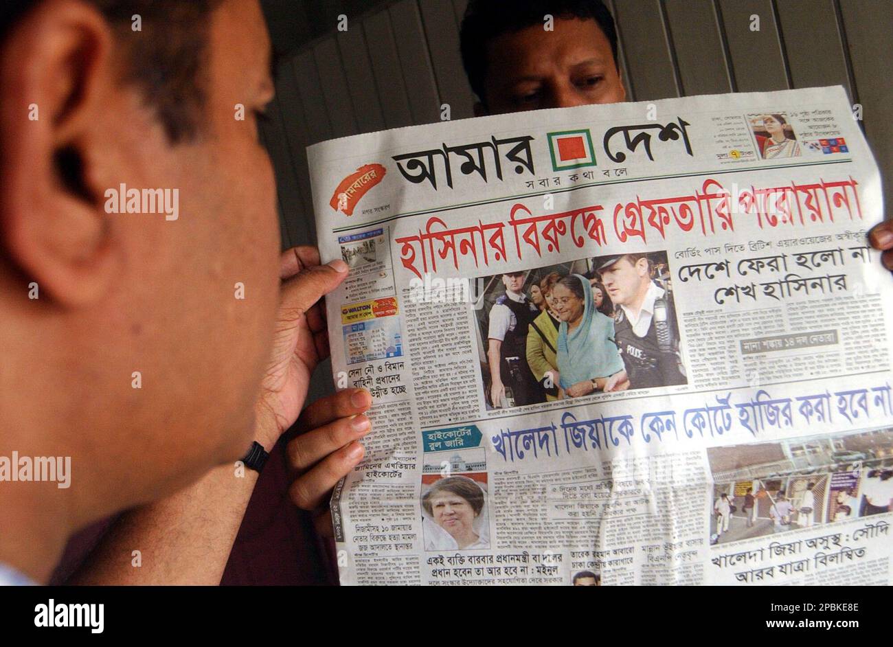 Bangladeshi commuters read the news of former Prime Minister Sheikh Hasina being blocked from ...