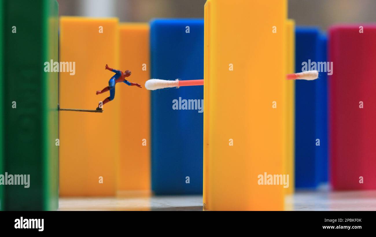 a miniature human figure with the power of a spider jumping over a ...