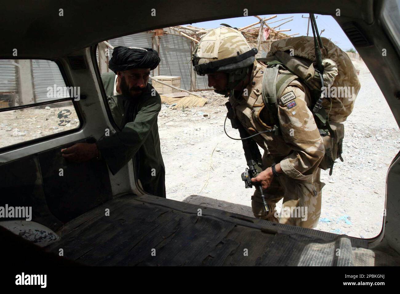A British soldier of Second Royal Regiment of Fusiliers inspects a car ...
