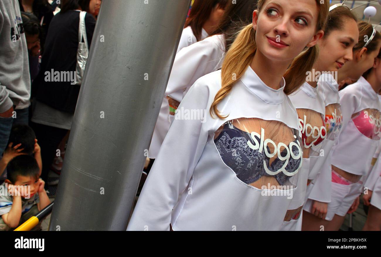 A child watches models in inner wears stroll in downtown Tokyo, in ...