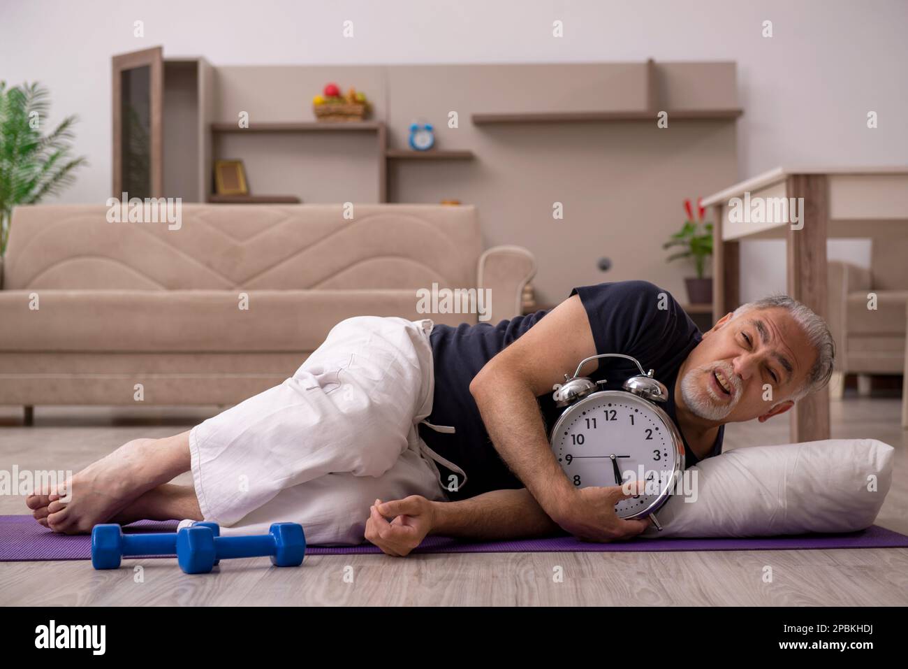 Old man doing sport exercises indoors Stock Photo - Alamy