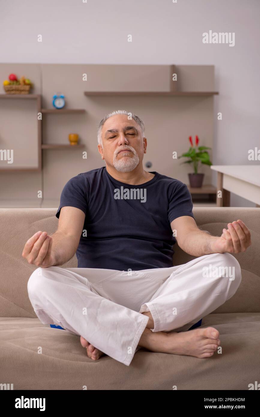 Old man doing sport exercises indoors Stock Photo - Alamy