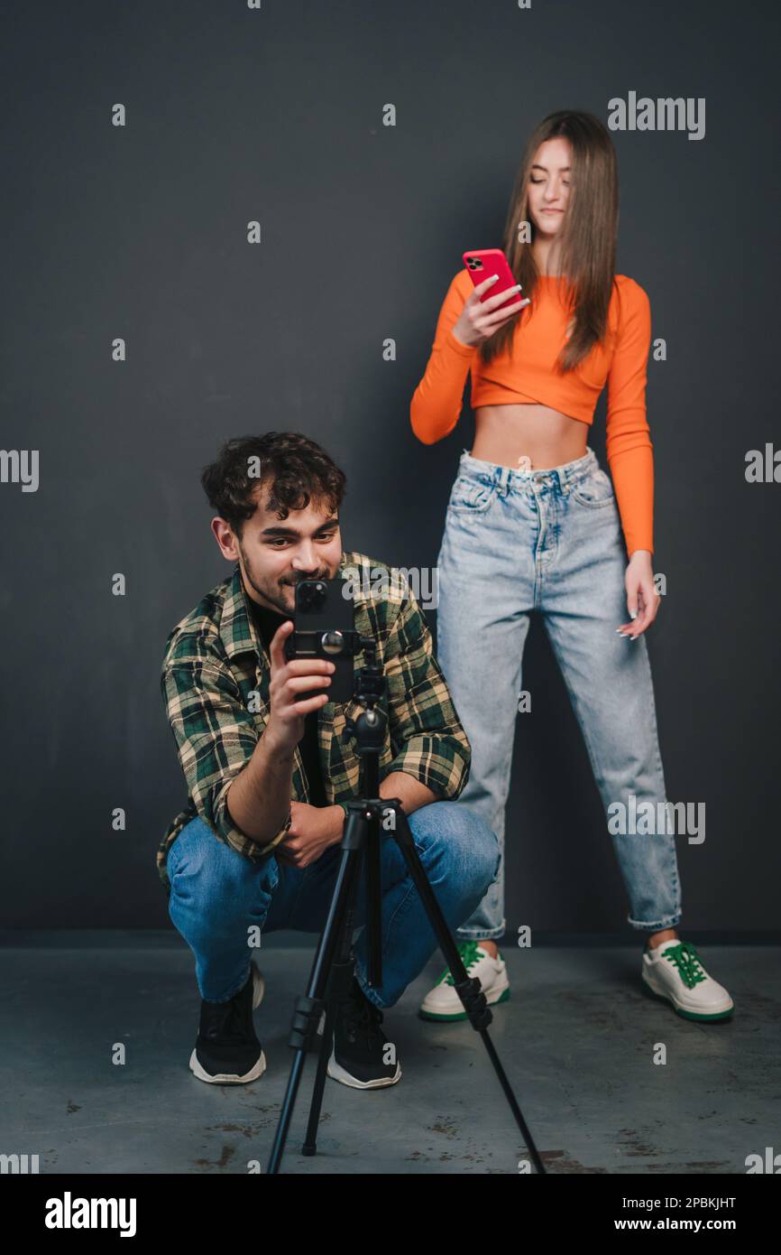 Caucasian young couple creating their dancing video with smartphone ...