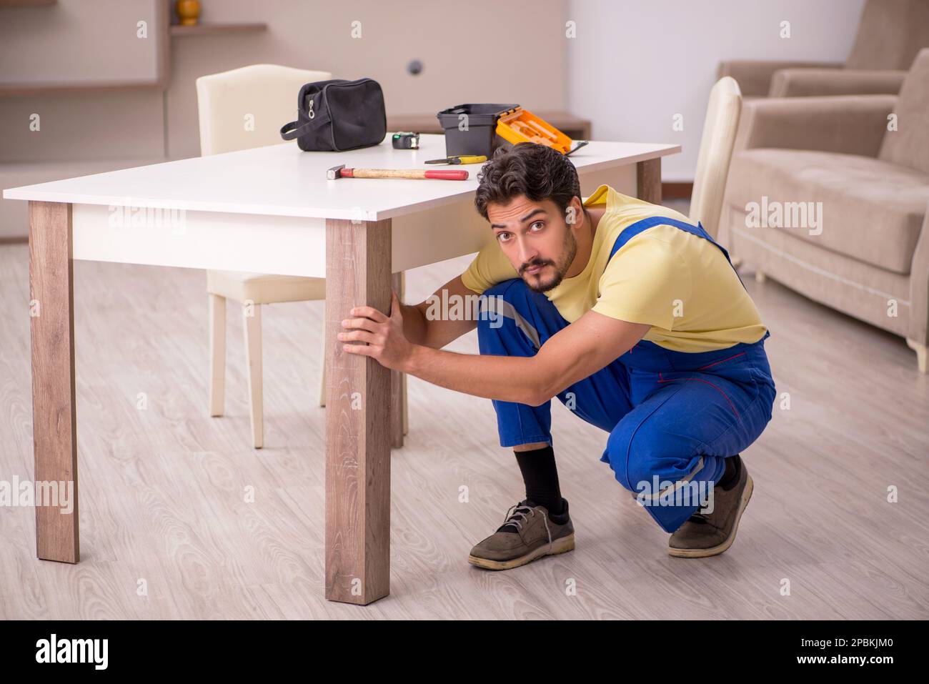 Man fixing leg table hi-res stock photography and images - Alamy