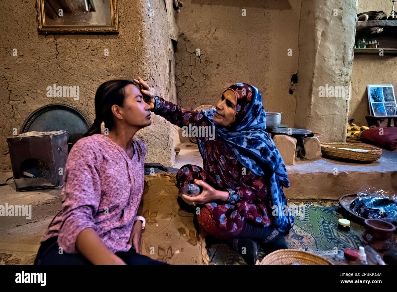 Applying moringa oil on a tourist, Bait al Safah, Al Hamra, Oman Stock ...