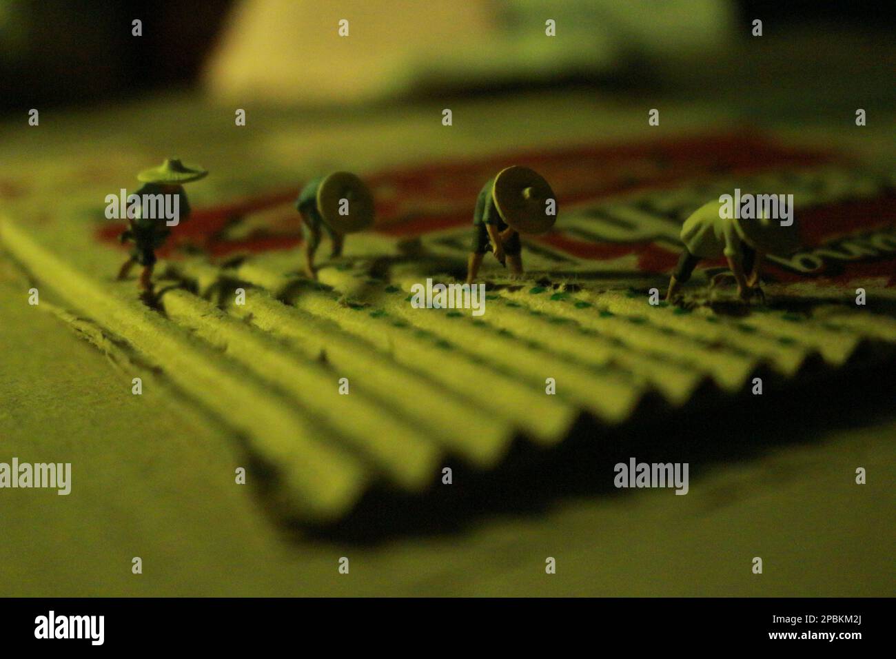a close up of miniature figures of farmers who are farming on cardboard ...