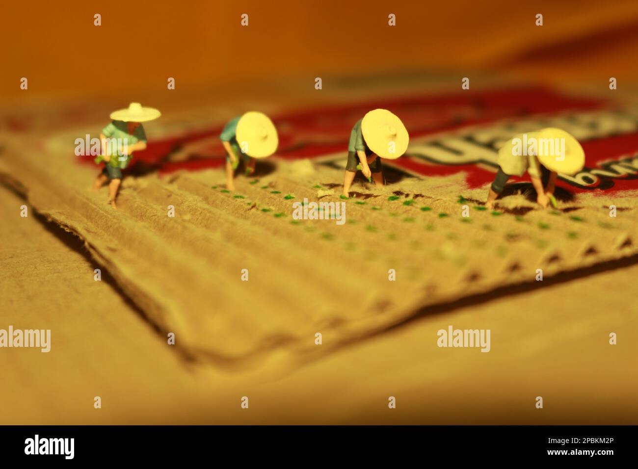 a close up of miniature figures of farmers who are farming on cardboard ...