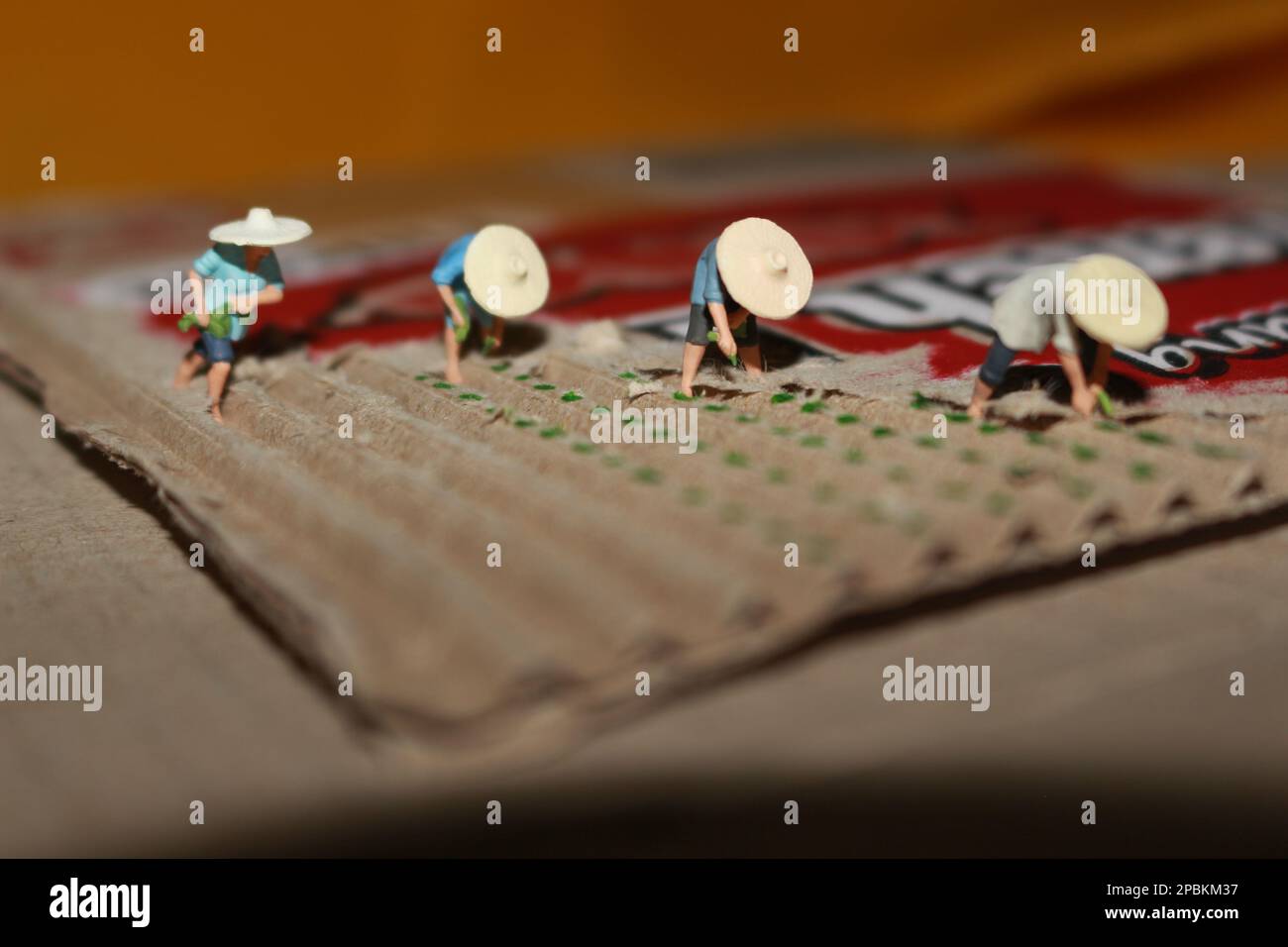 a close up of miniature figures of farmers who are farming on cardboard ...