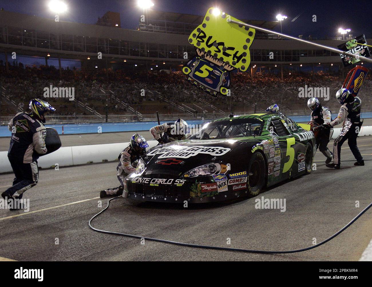 Pit crew members scramble to change tires and fuel Kyle Busch's car ...
