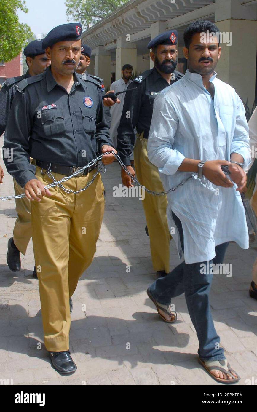 Pakistani police officers escort a handcuffed suspect Adnan Mahmood ...