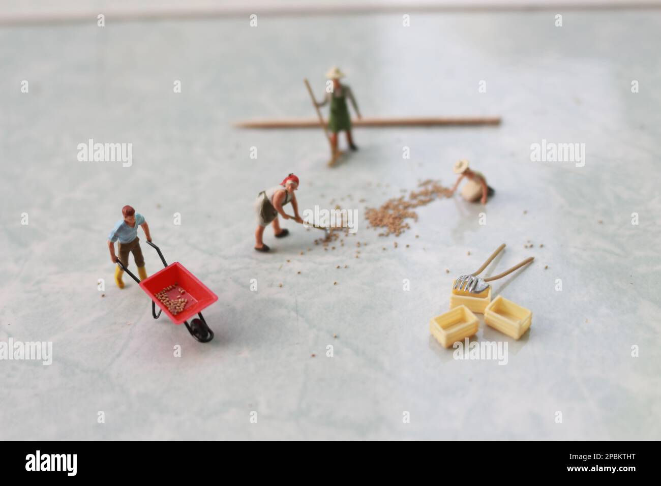 miniature figures of workers working together to move grain Stock Photo ...