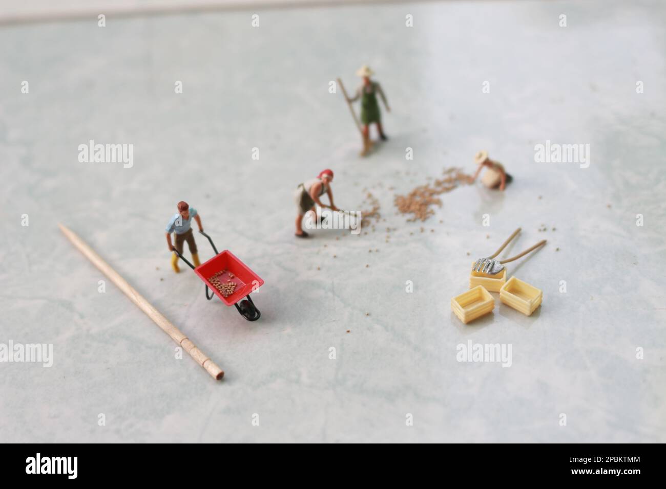 miniature figures of workers working together to move grain Stock Photo ...