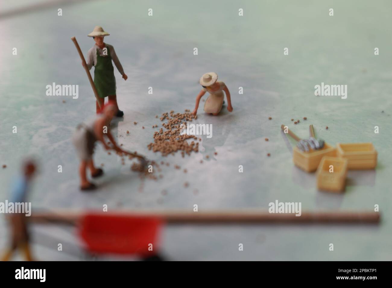 miniature figures of workers working together to move grain Stock Photo ...