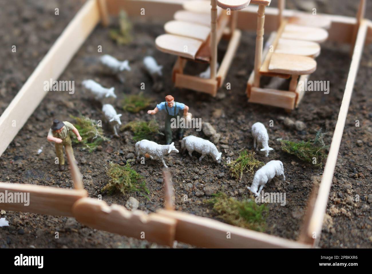 A close up of miniature figure of a goat herder feeding in a wooden ...