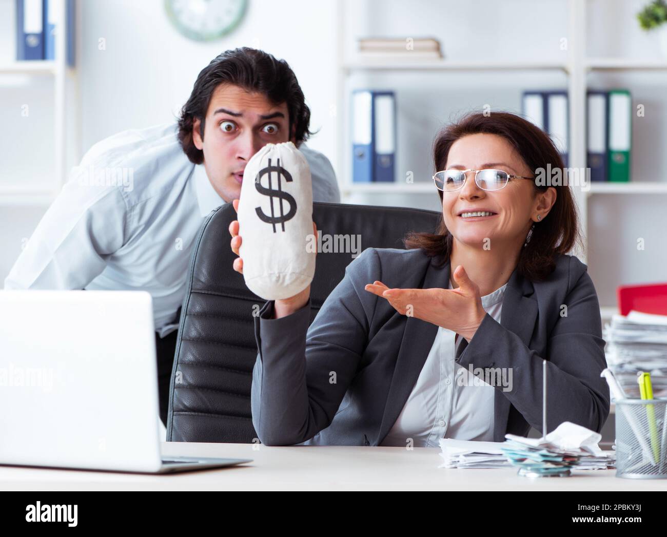 The old female boss and young male employee in the office Stock Photo ...