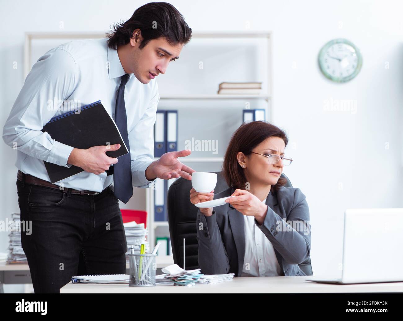 The old female boss and young male employee in the office Stock Photo ...
