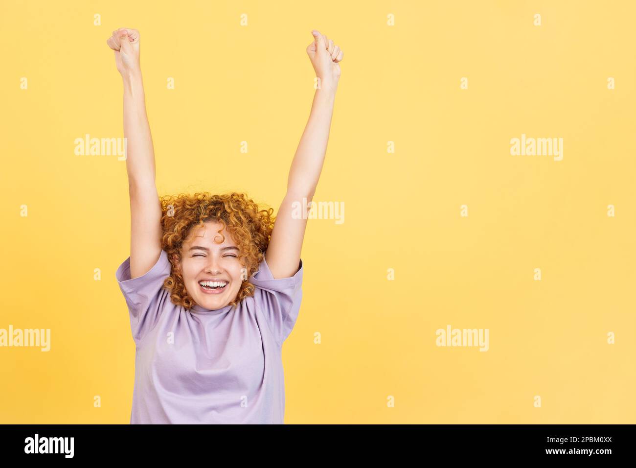 Woman celebrating while raising the arms and smiling Stock Photo - Alamy