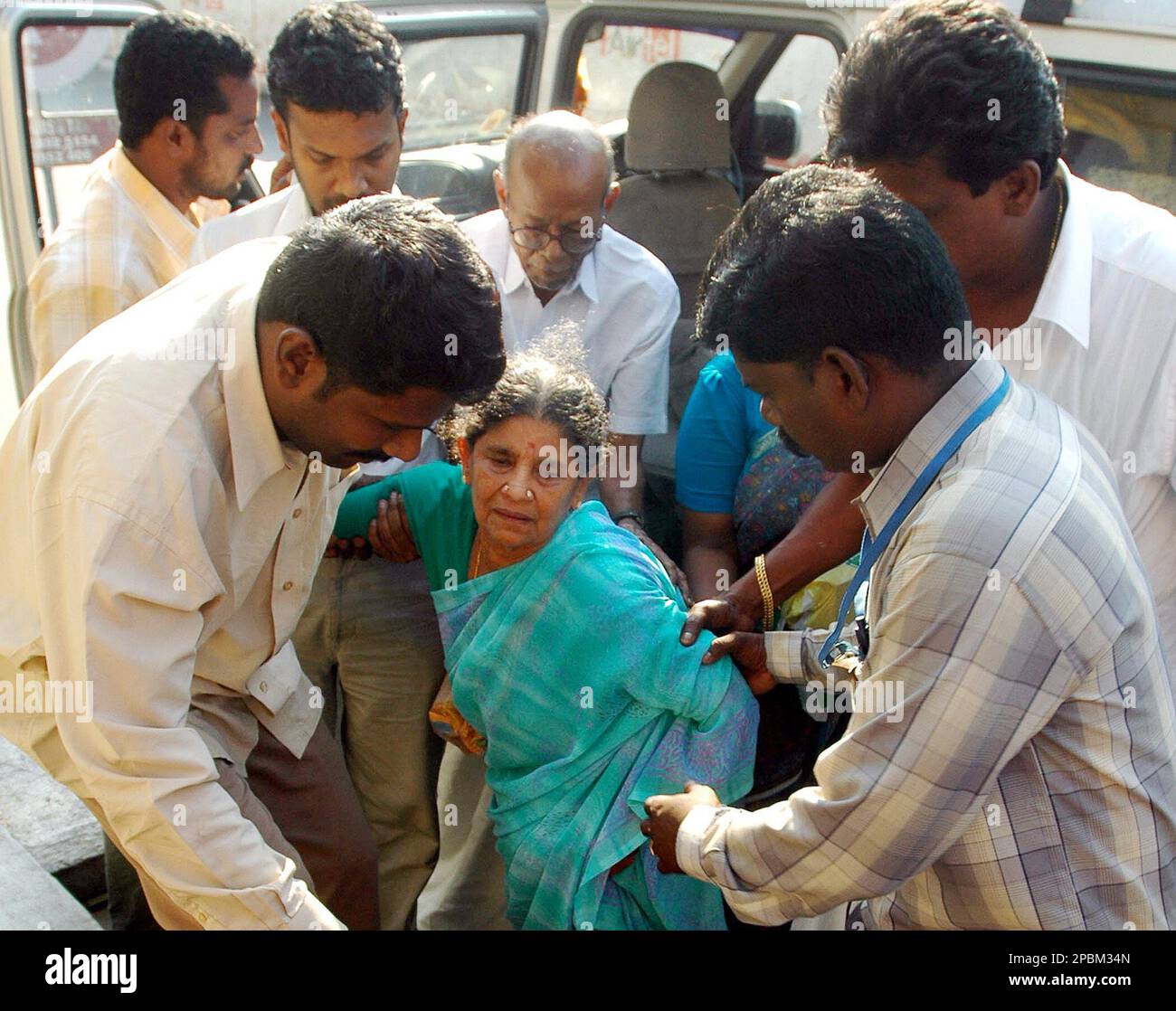 Family members assist Kaliammal, 74, mother of G.V.Loganathan, to step ...