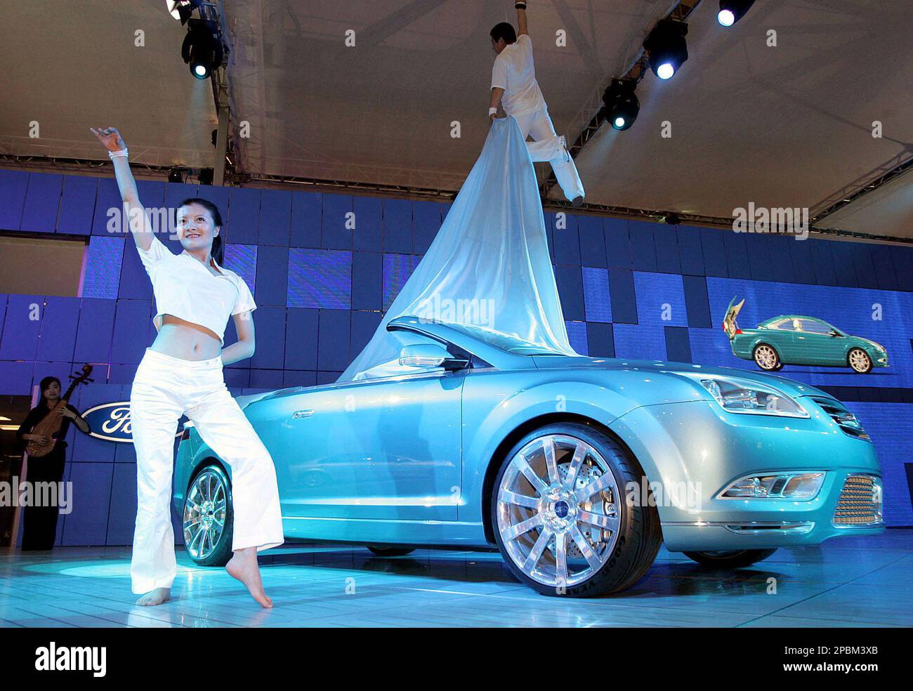 ** FILE ** Models poses next to a Ford Focus concept car at pre-opening ...