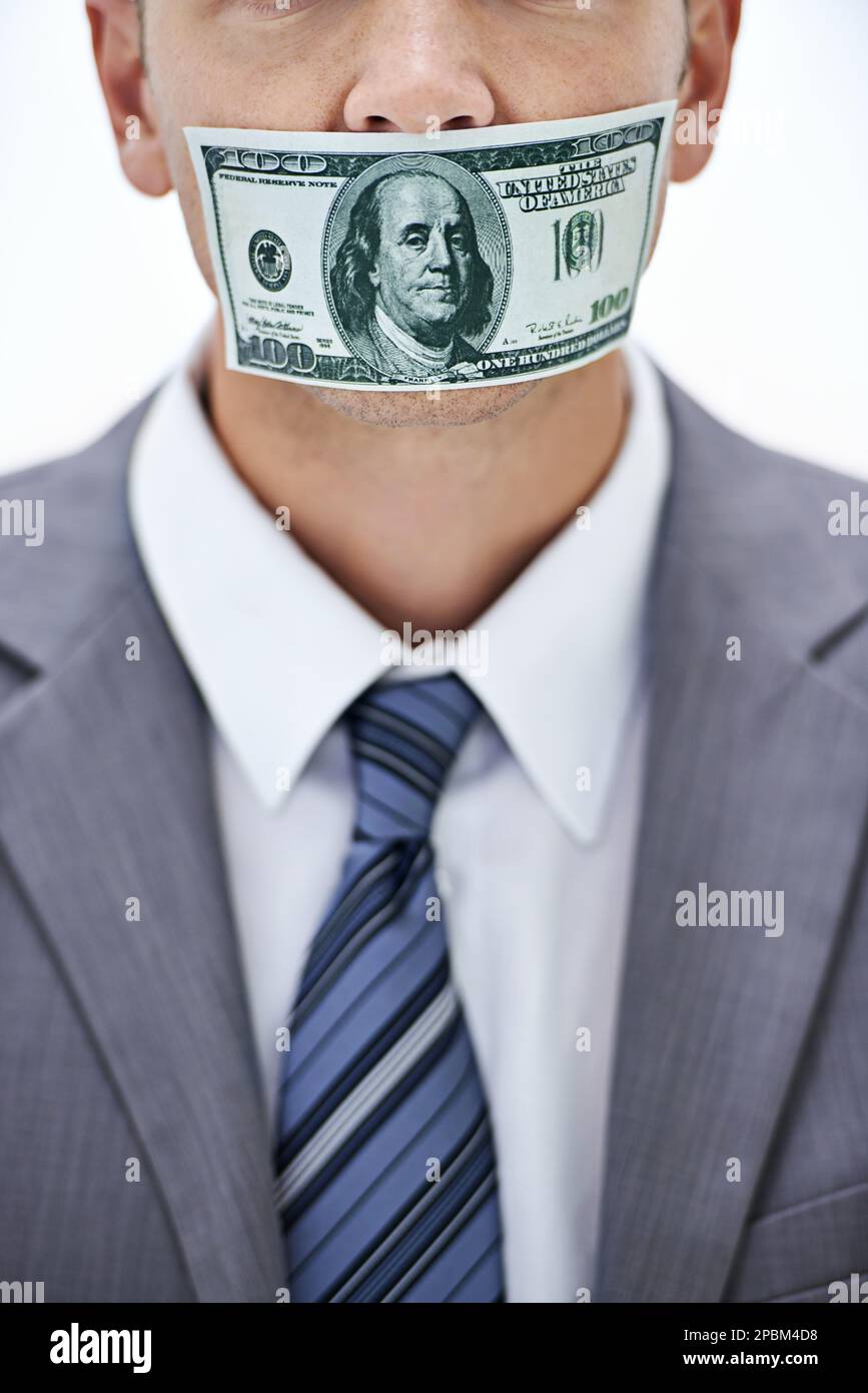 Dont say a word...A businessman with his mouth covered with paper money ...