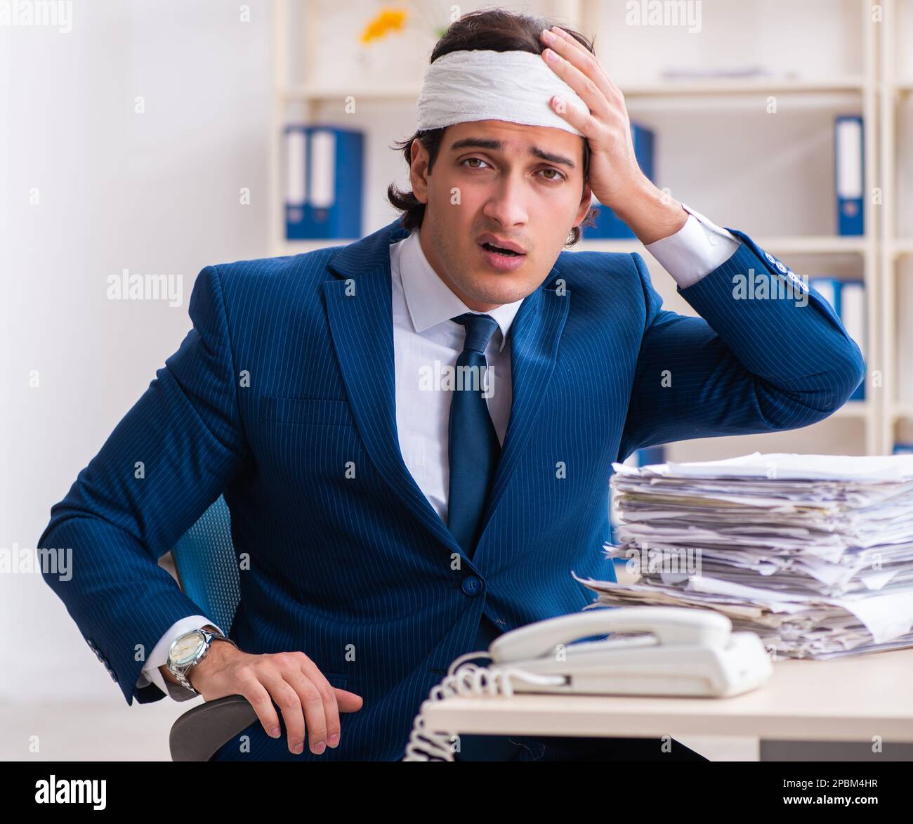 The head injured male employee working in the office Stock Photo - Alamy