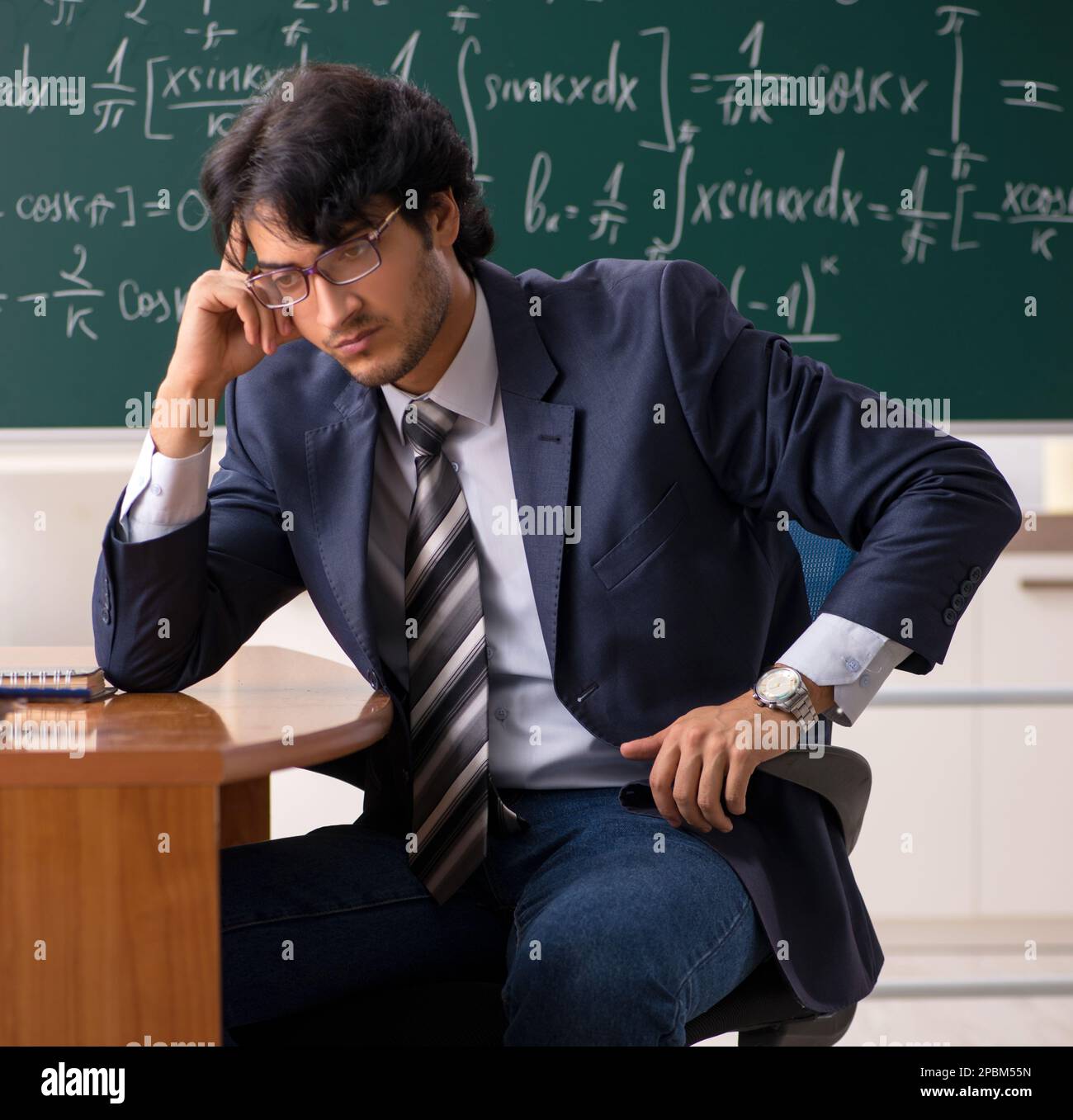 The young male math teacher in classroom Stock Photo - Alamy