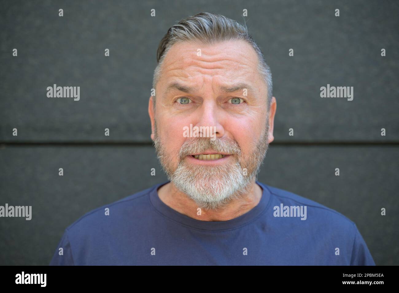 Senior man looking at the camera in panic with a wide eyed expression ...