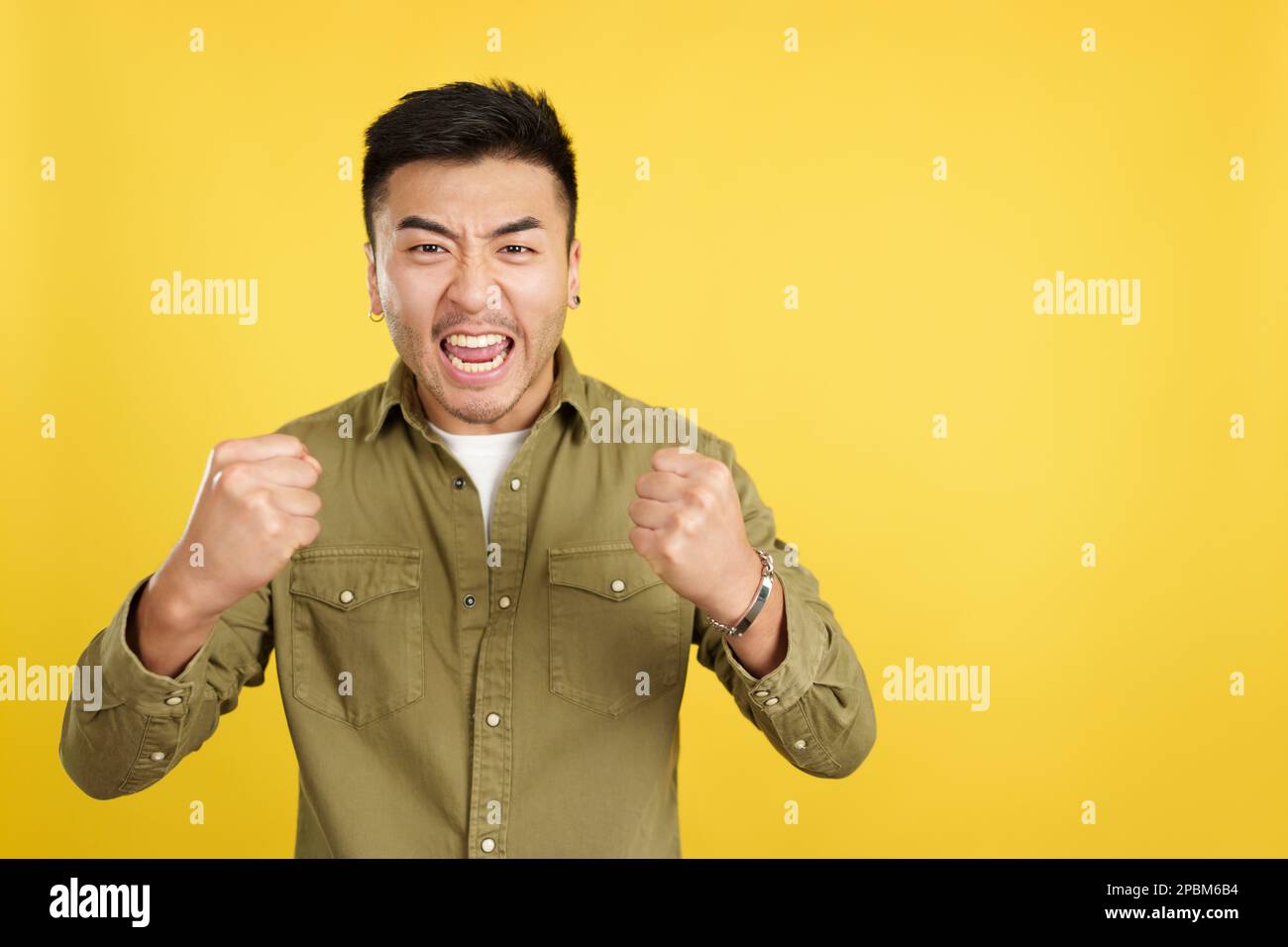 Excited chinese man celebrating while raising arms Stock Photo - Alamy