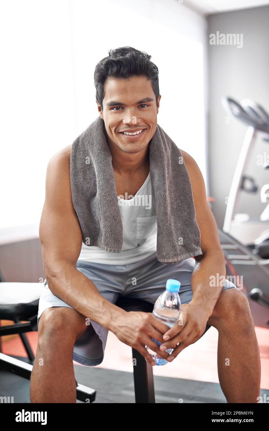 Staying in control of my fitness. A smiling young man sitting on a ...