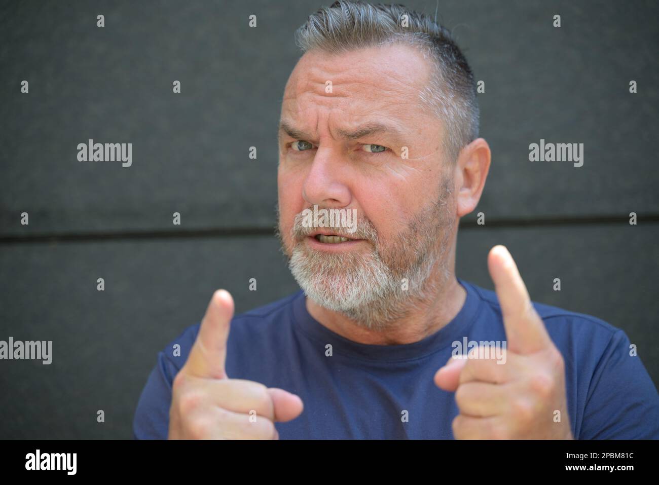 Argumentative man making a point wagging his fingers at the camera as ...