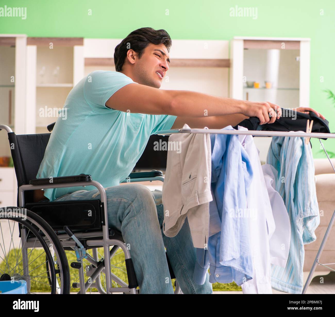 The disabled man on wheelchair doing laundry Stock Photo - Alamy