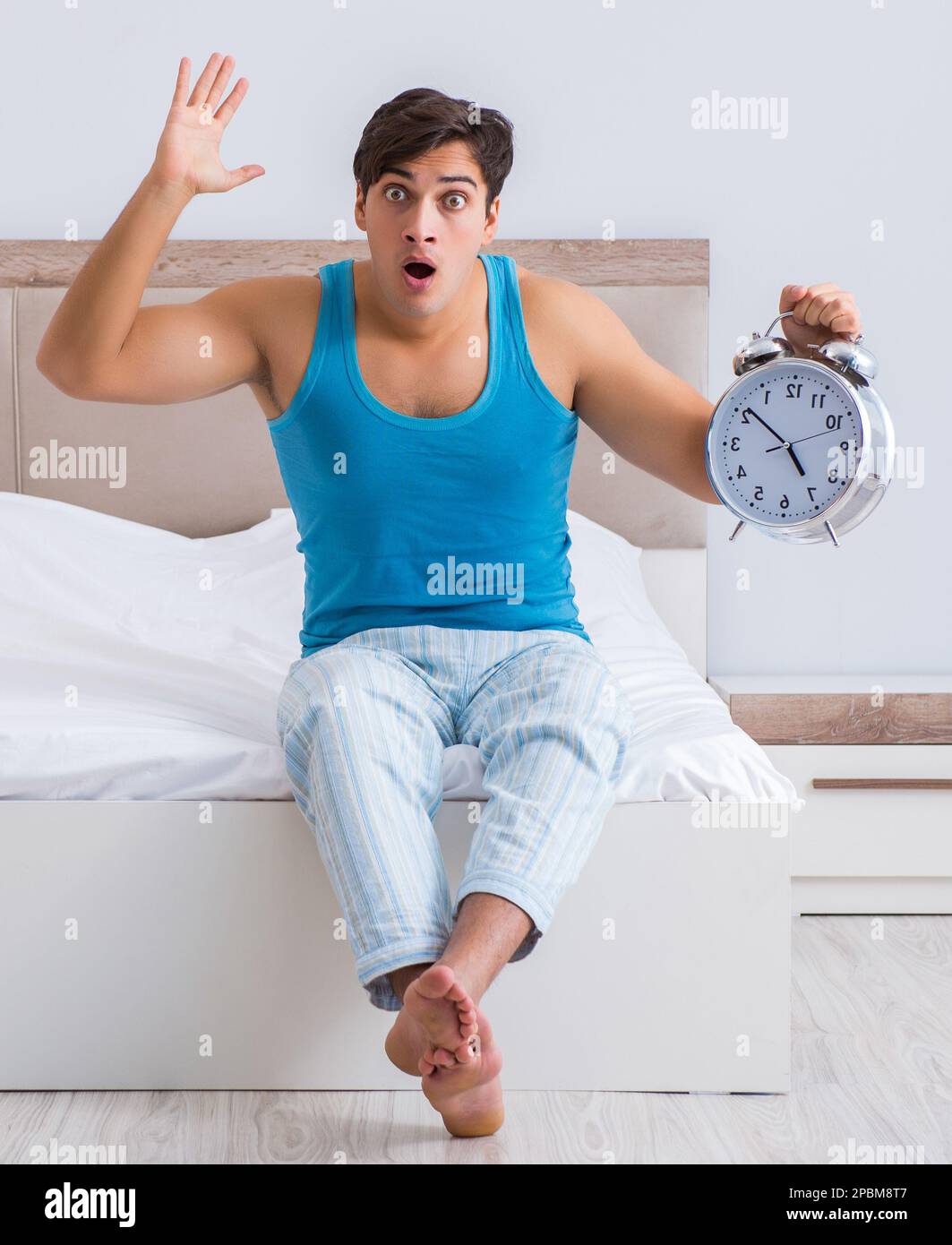 The young man waking up in bed Stock Photo - Alamy