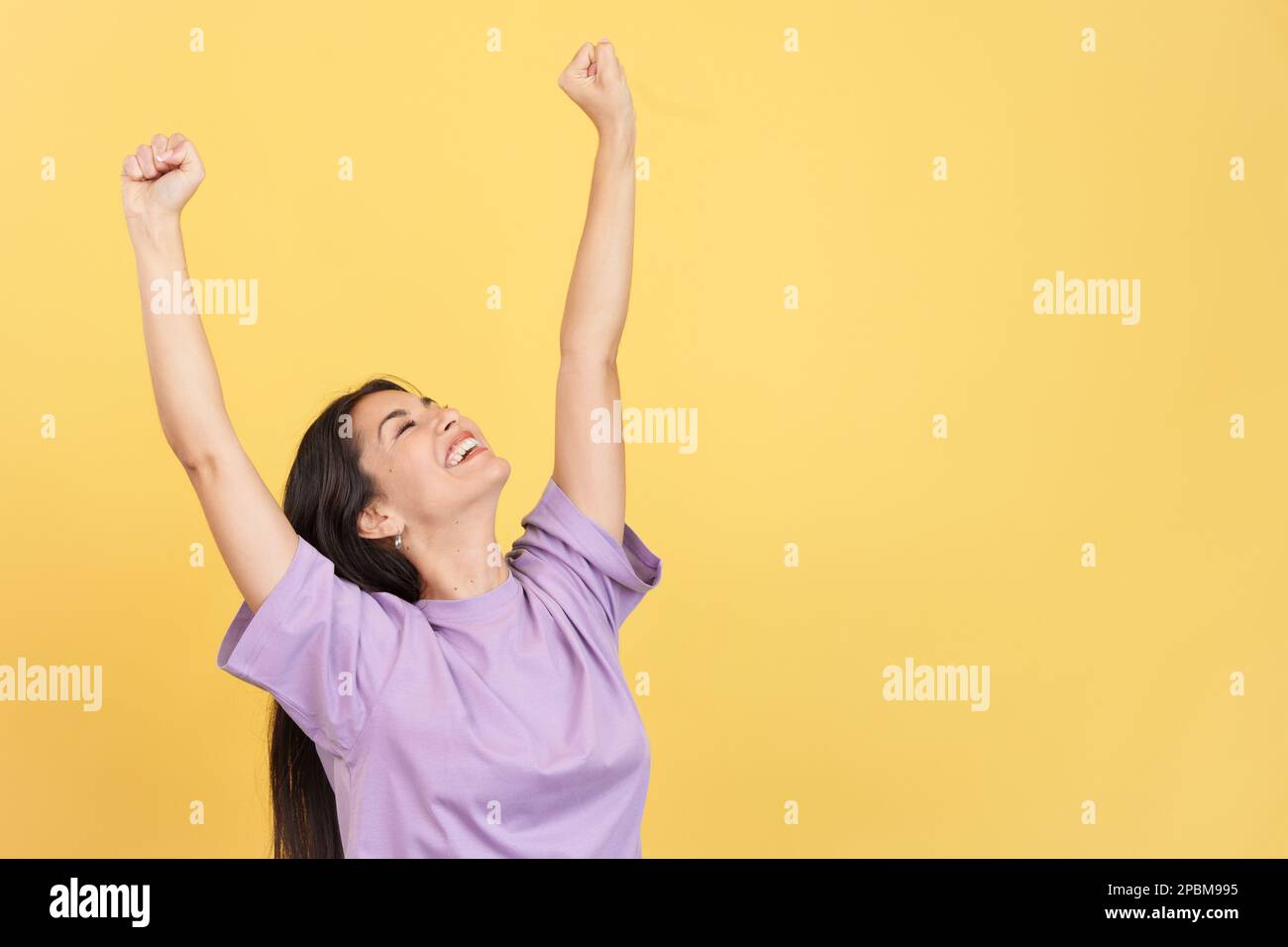 Happy caucasian woman celebrating while raising arms Stock Photo - Alamy