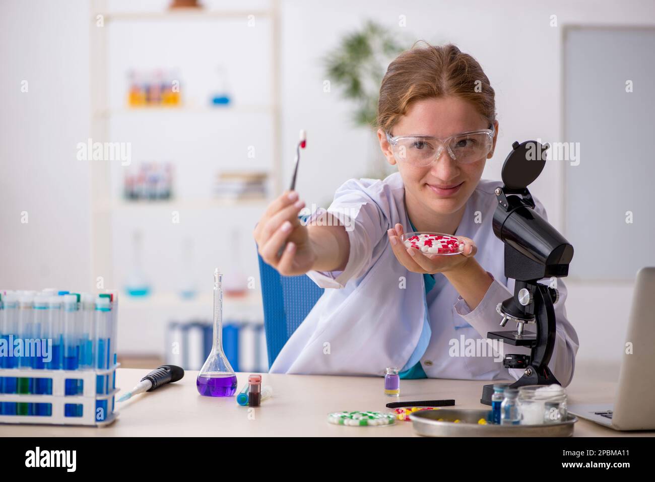 Young girl chemist in drugs synthesis concept Stock Photo - Alamy