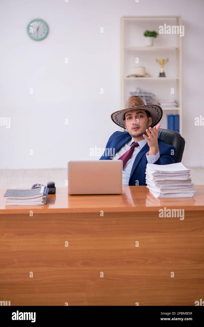 Young cowboy employee working at workplace Stock Photo - Alamy