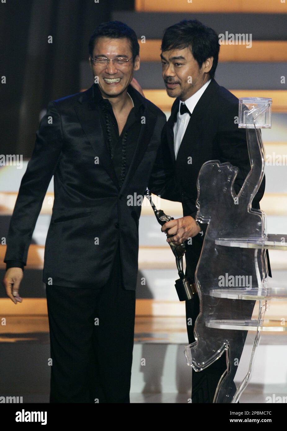 Hong Kong actor Lau Ching Wan, right, receives his trophy for the Best ...