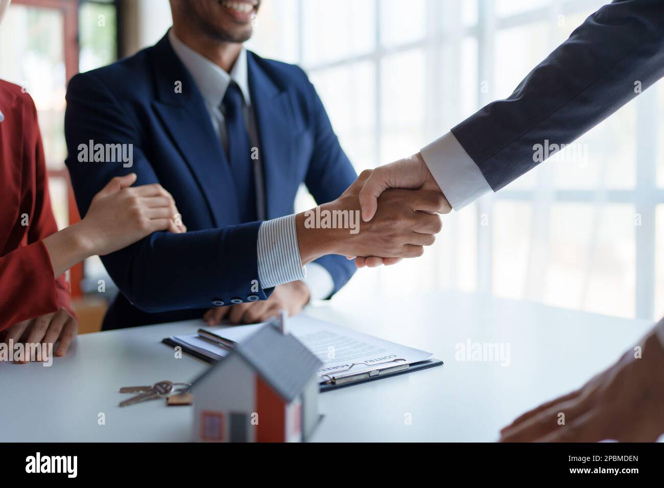 Asian real estate agent shaking hands handing over house and keys to ...
