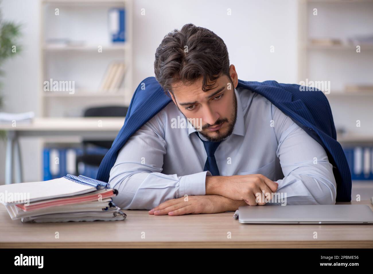 Young businessman employee extremely tired at workplace Stock Photo - Alamy
