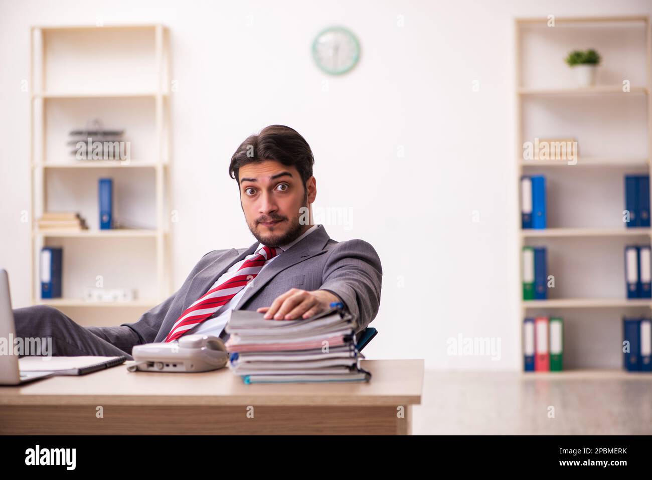 Young male employee working at workplace Stock Photo - Alamy