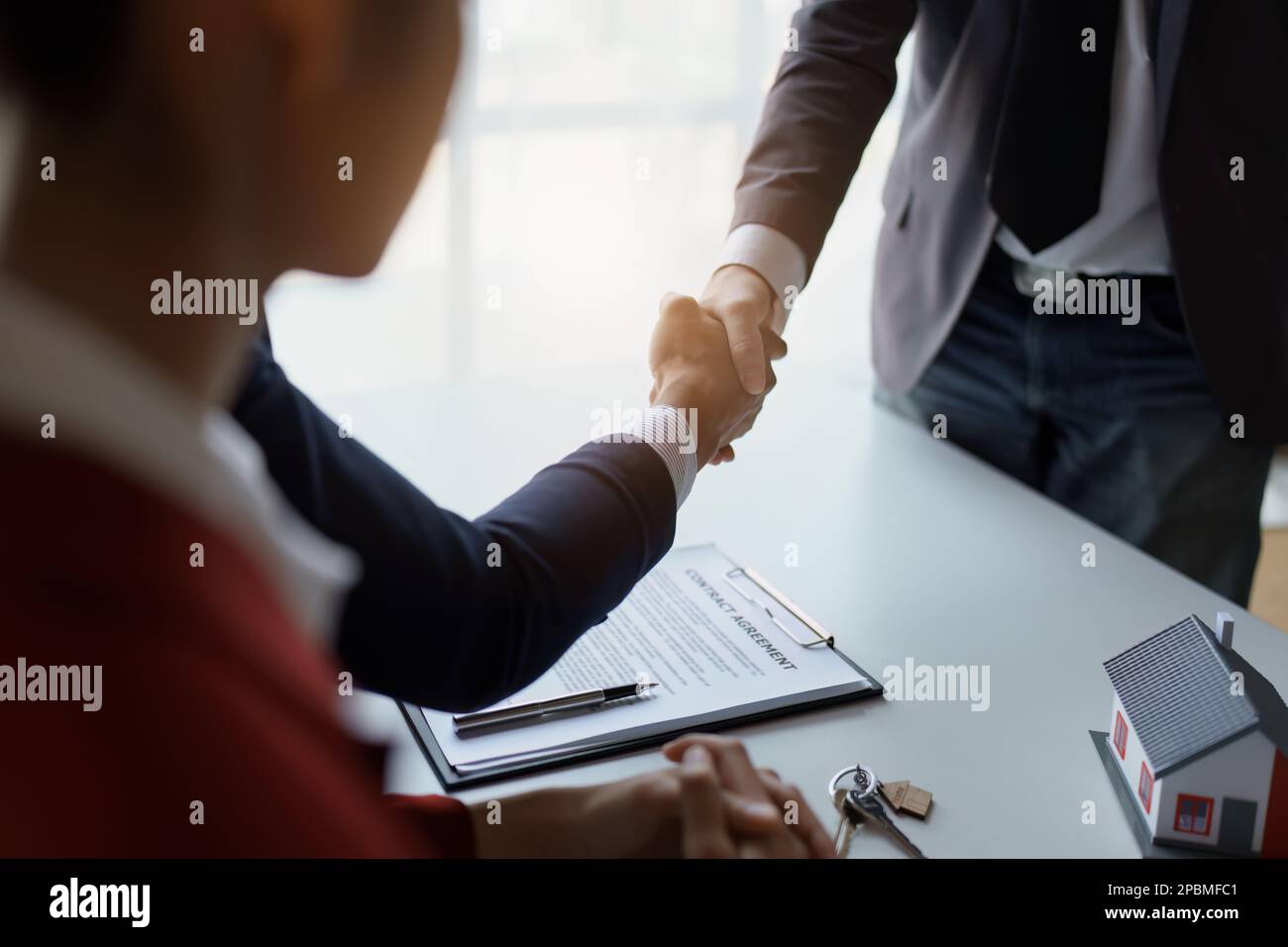Asian real estate agent shaking hands handing over house and keys to ...