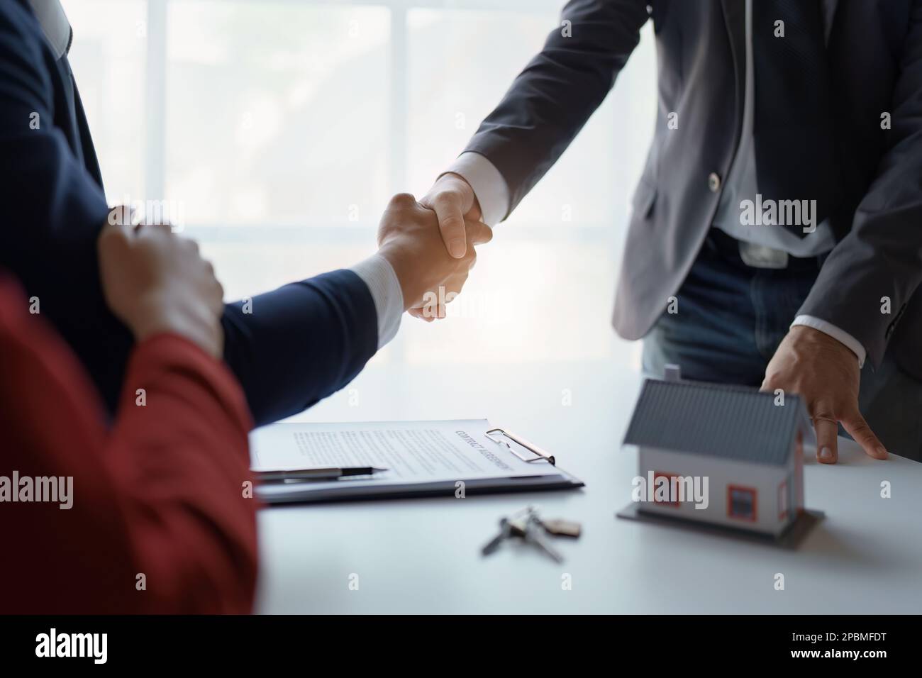 Asian real estate agent shaking hands handing over house and keys to ...