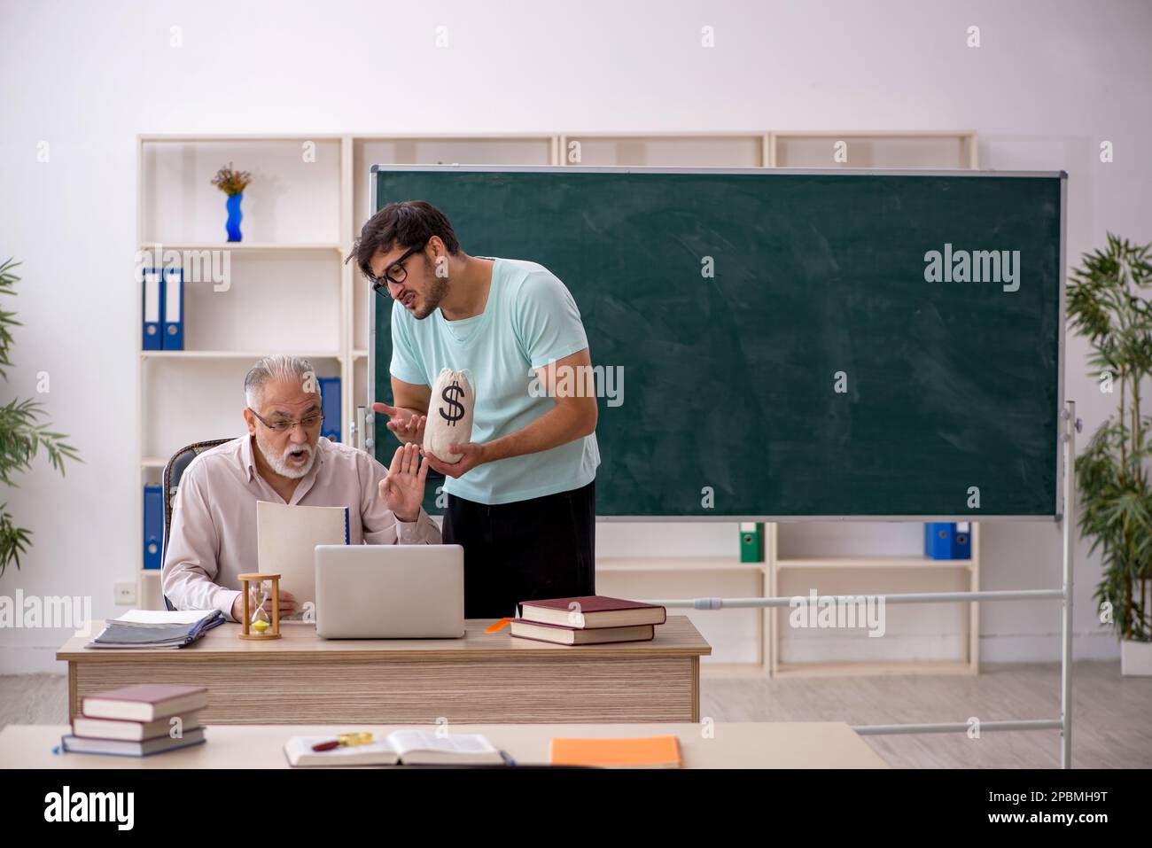 Old teacher and young student in remuneration concept Stock Photo - Alamy
