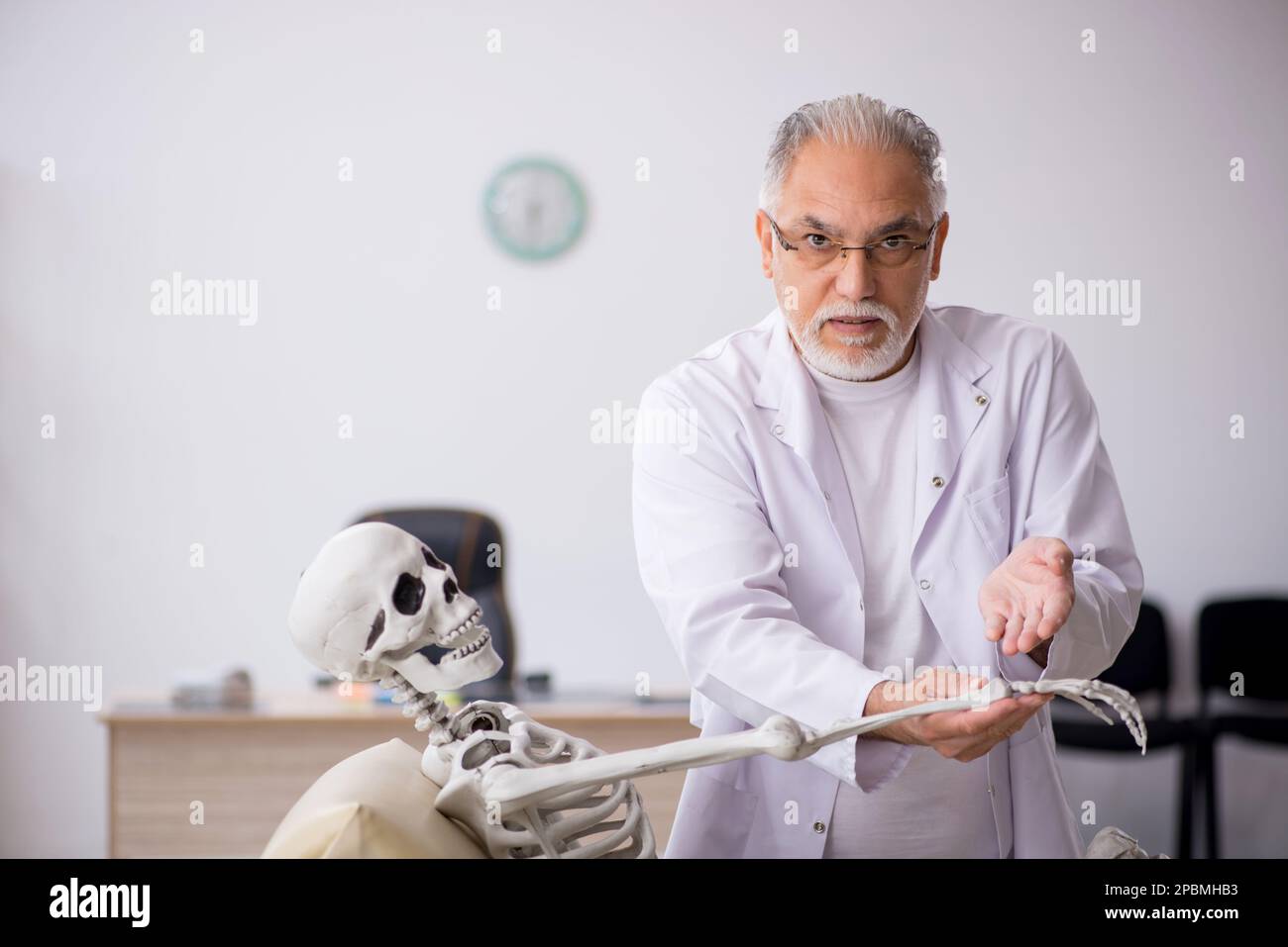 Old doctor with skeleton at the hospital Stock Photo - Alamy