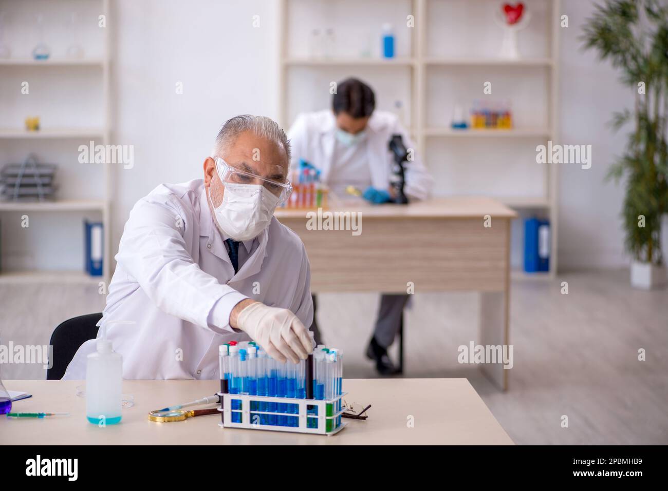 Two chemist working at the lab Stock Photo - Alamy