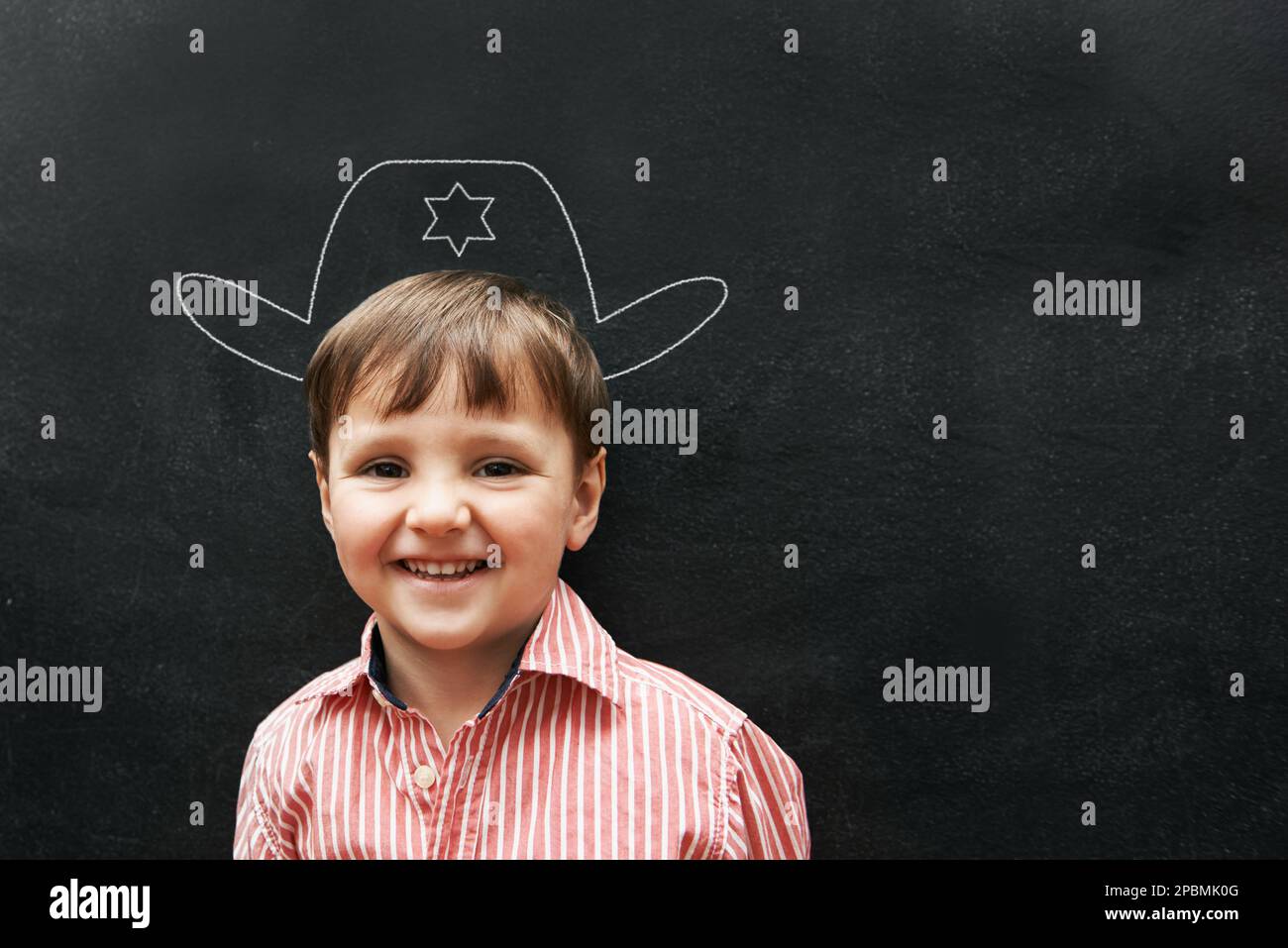 Drawing is so fun. Studio shot of an adorable little boy with chalk ...