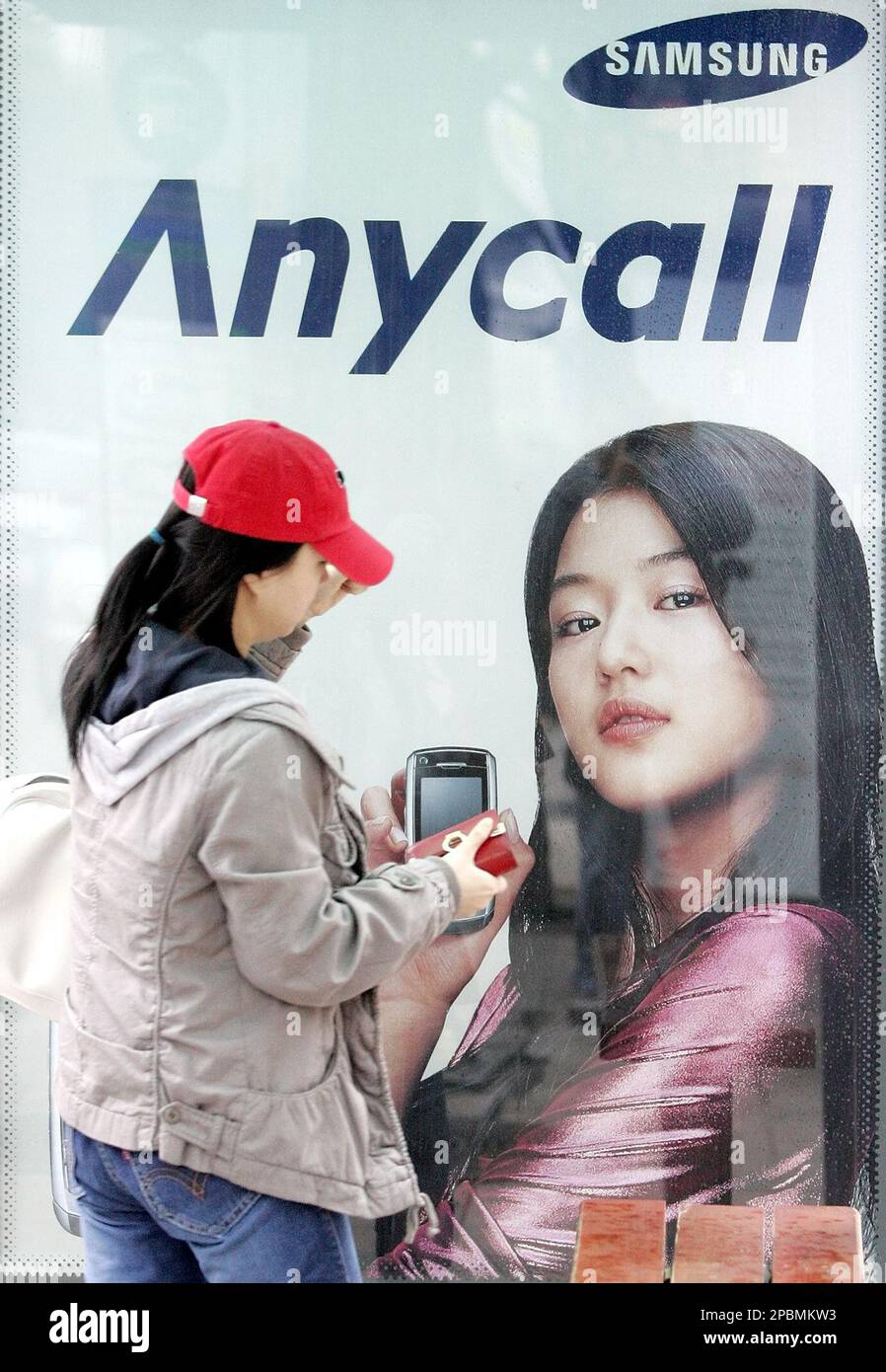 A South Korean woman walks past a Samsung mobile phone advertisement ...