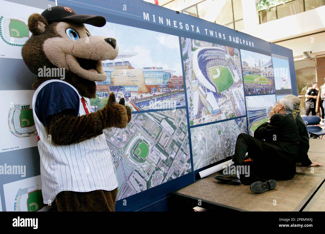 Minnesota Twins mascot T. C. Bear, left, gives the thumbs up as two ...