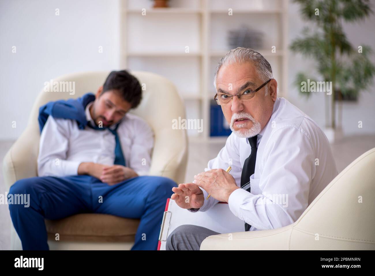 Young businessman visiting old psychologist Stock Photo - Alamy