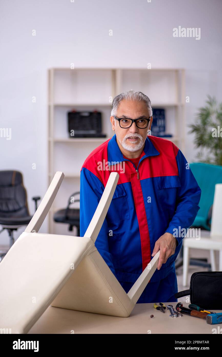 Old carpenter repairing chair at home Stock Photo - Alamy